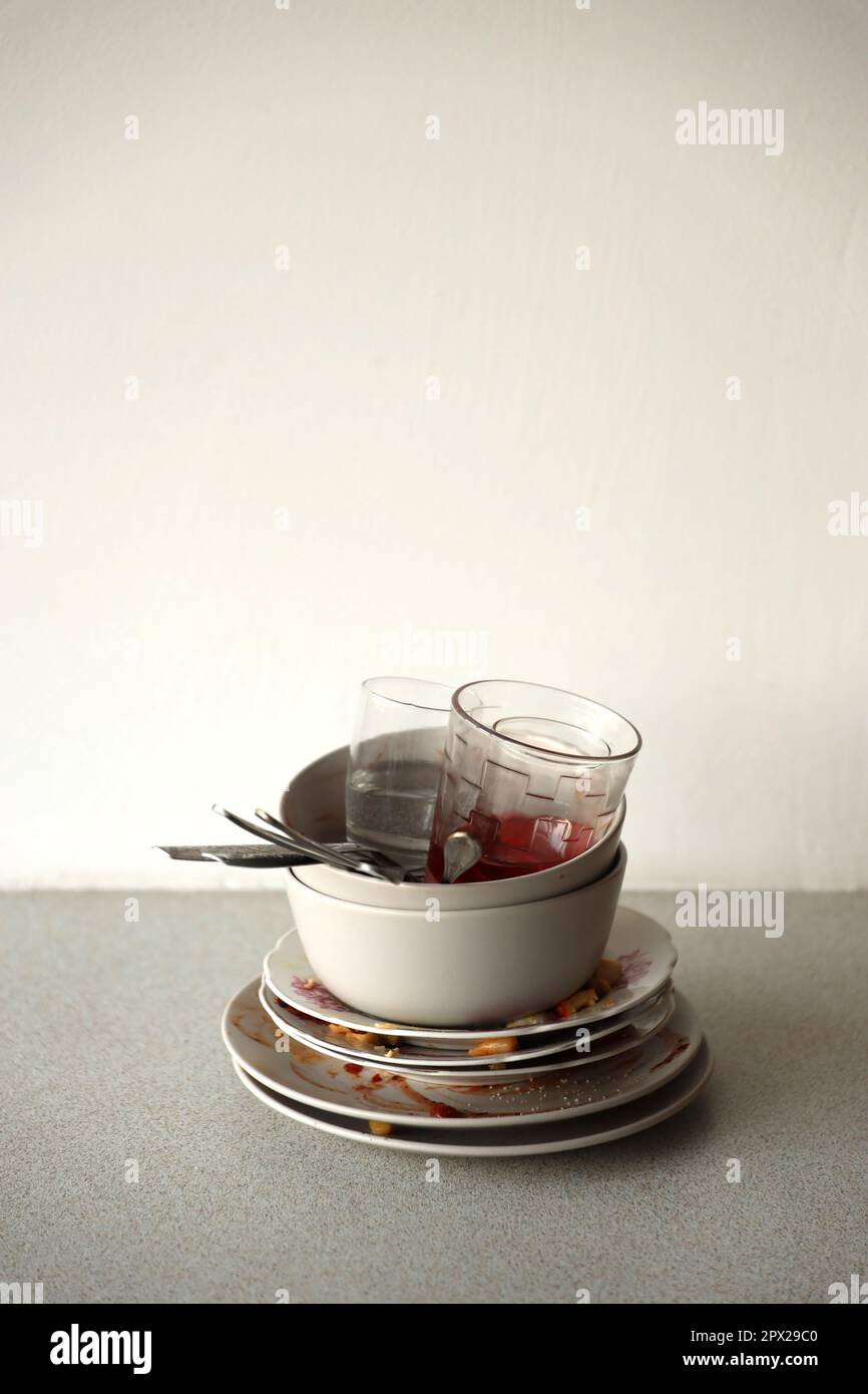 Stack of dirty dishes with food leftovers on the table after meal ...