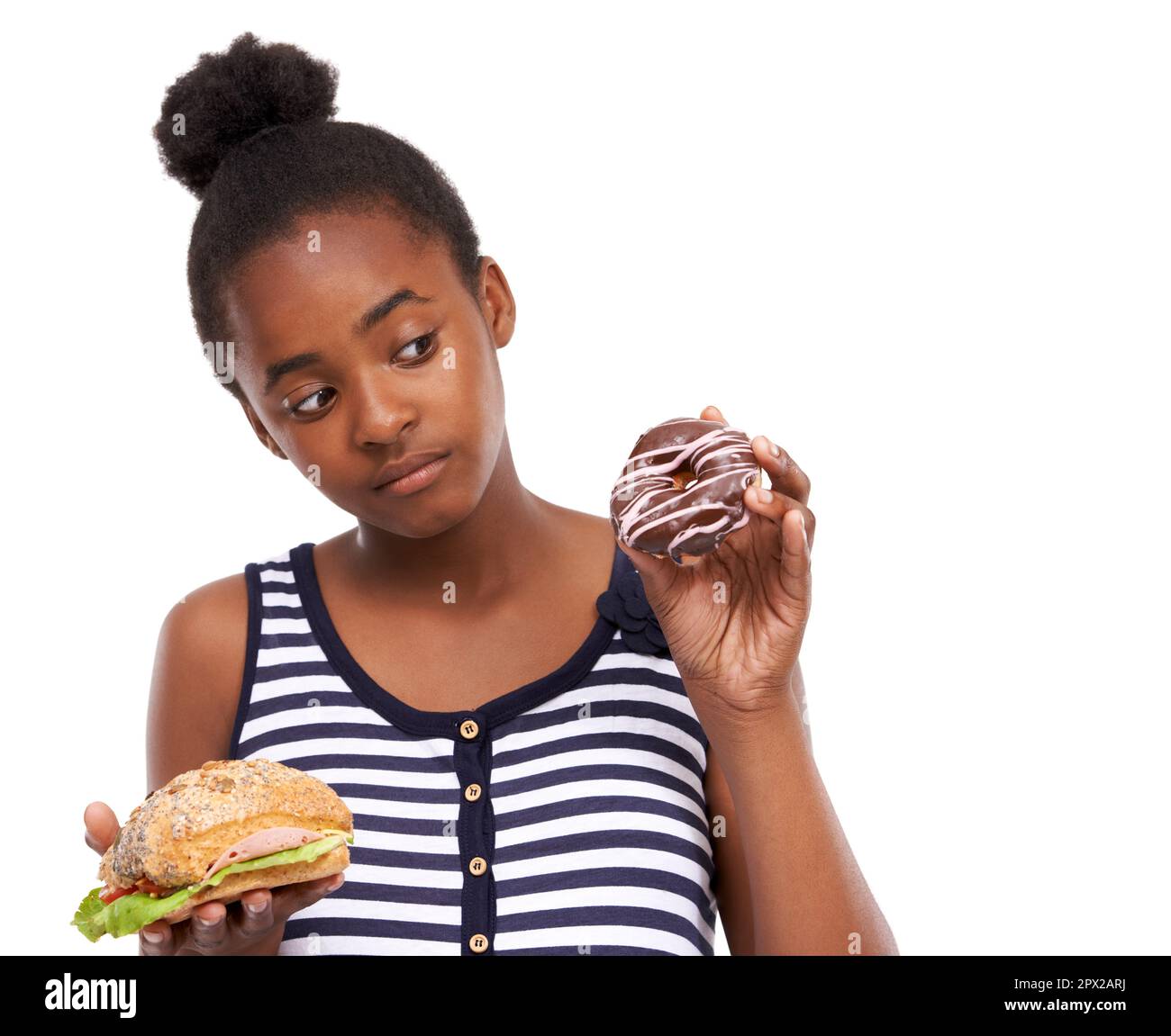Trying to make the healthy choice. a young african american girl trying ...