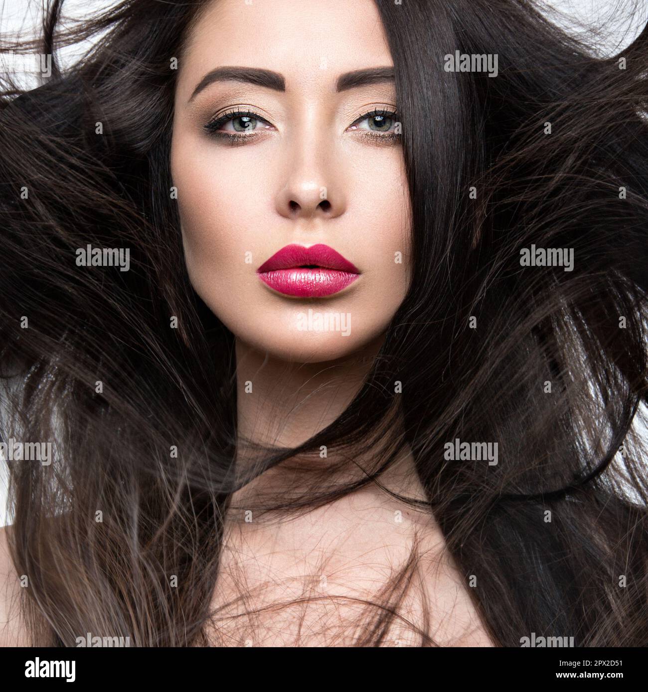 Beautiful girl with evening makeup, pink lips and the wind in hair ...