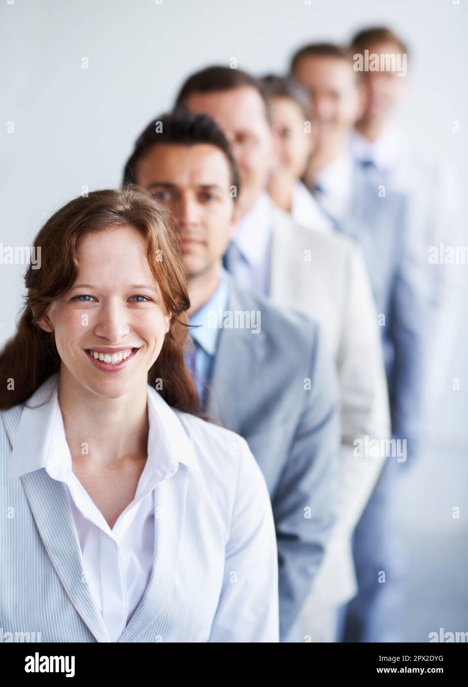 They respect her leadership. A pretty businesswoman standing with her ...