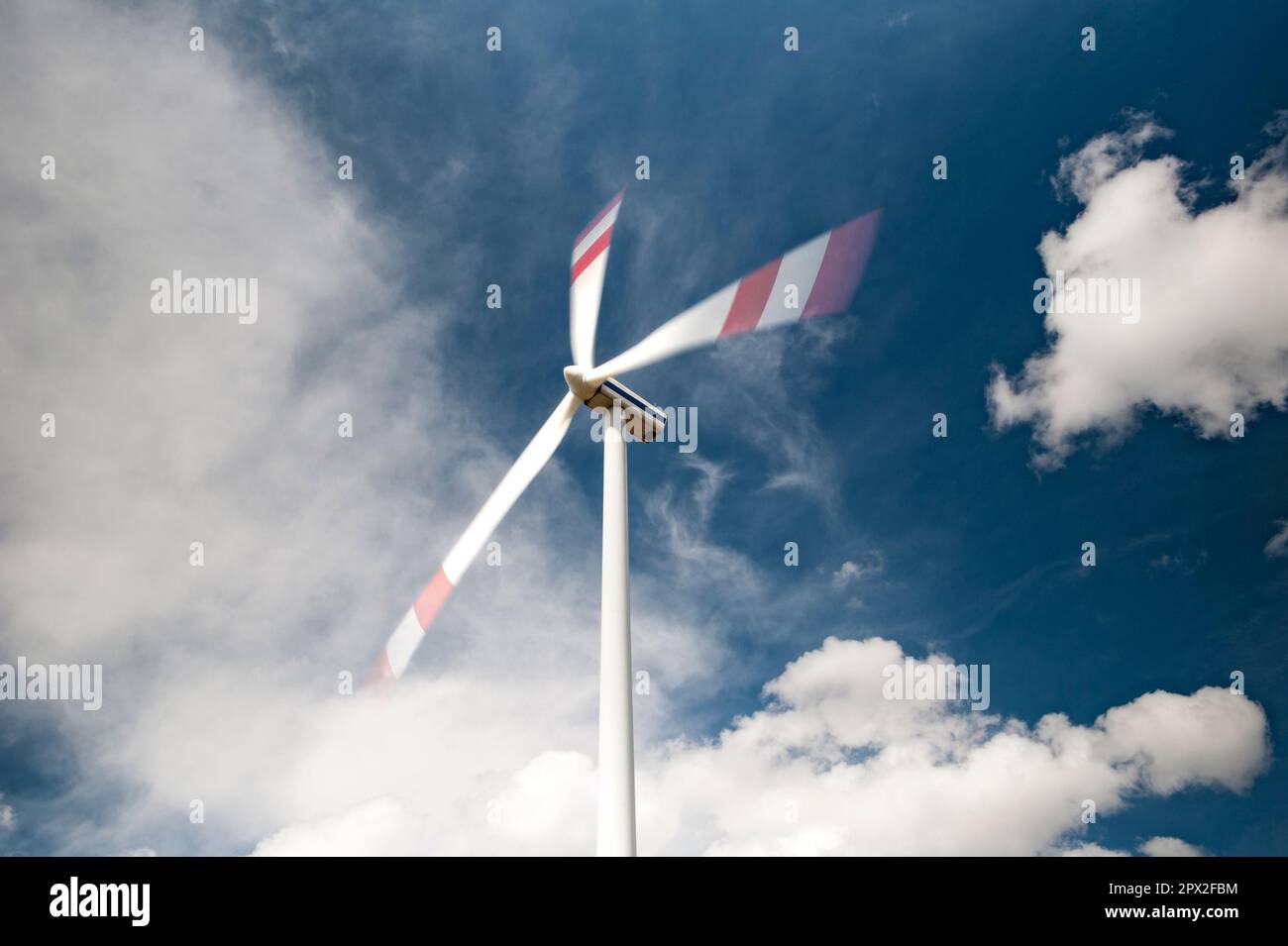 The rotor blades of a wind turbine, blurred by the rotation, in the ...