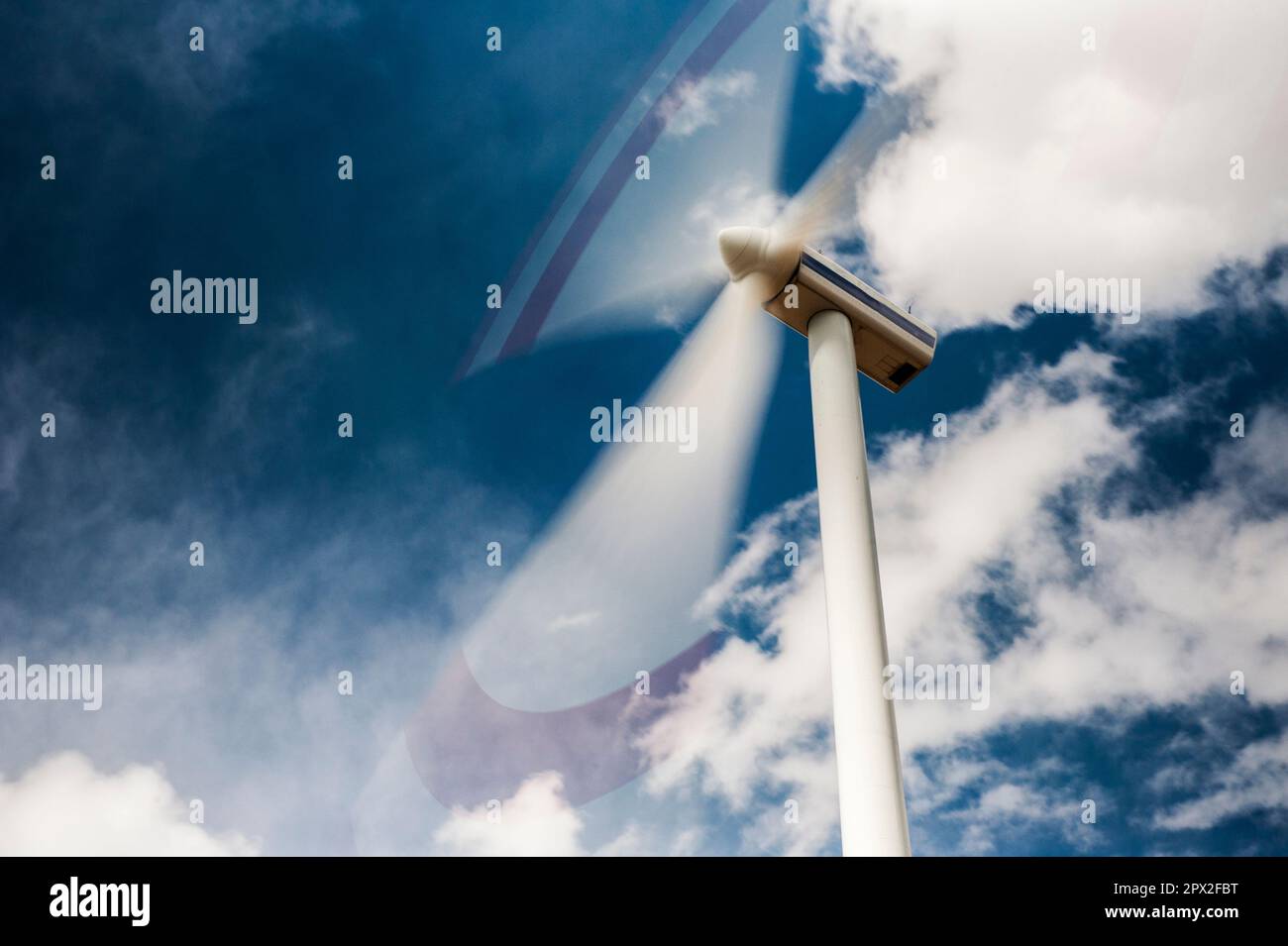 The rotor blades of a wind turbine, blurred by the rotation, in the ...