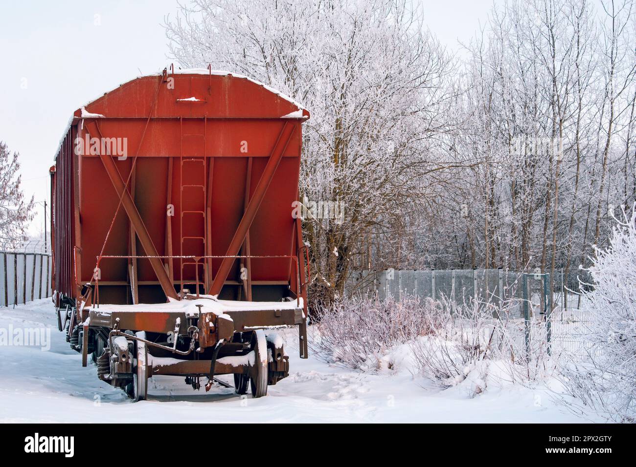 Carriages of a cargo train standing a snow covered railway line. Winter ...