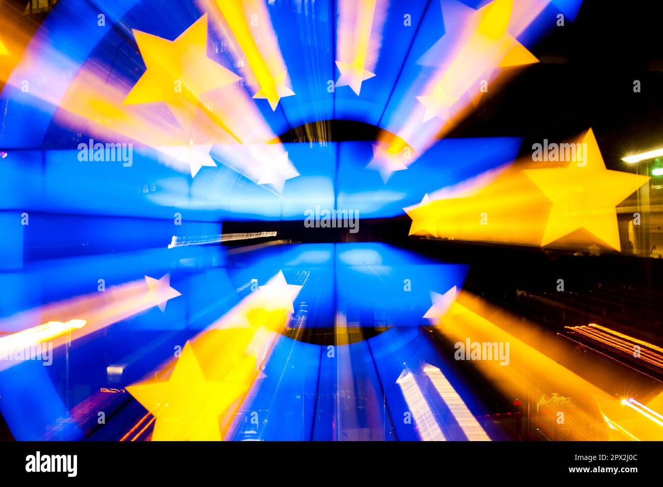 The blue-yellow euro symbol at night with zoom effect and blurred ...