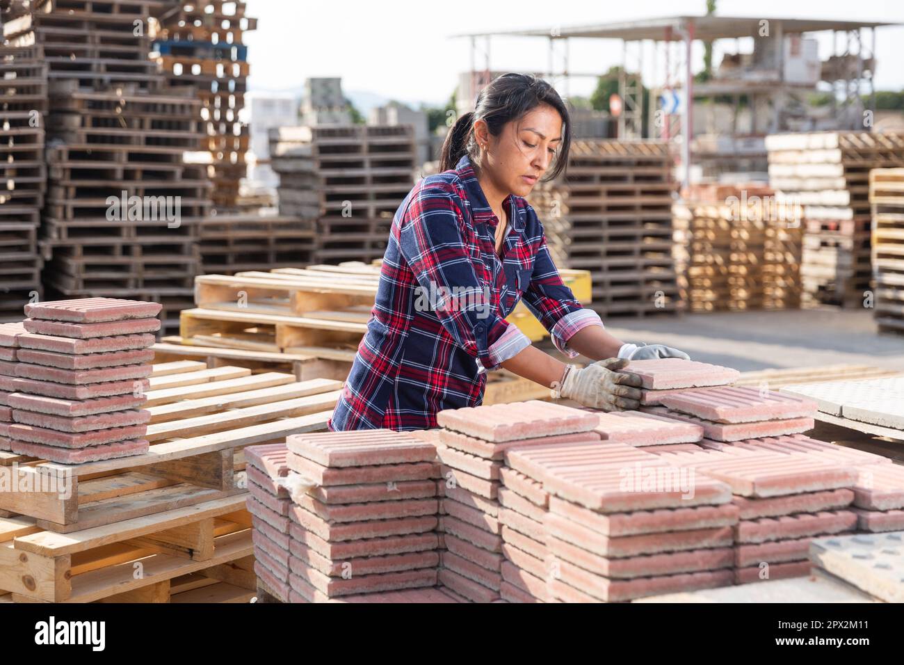 Latin american female stacking tiles on pallet Stock Photo - Alamy