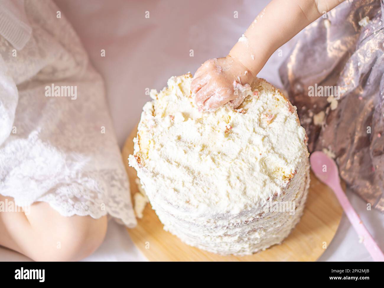 Hand of the little girl is smashing a beautiful delicious cake for ...