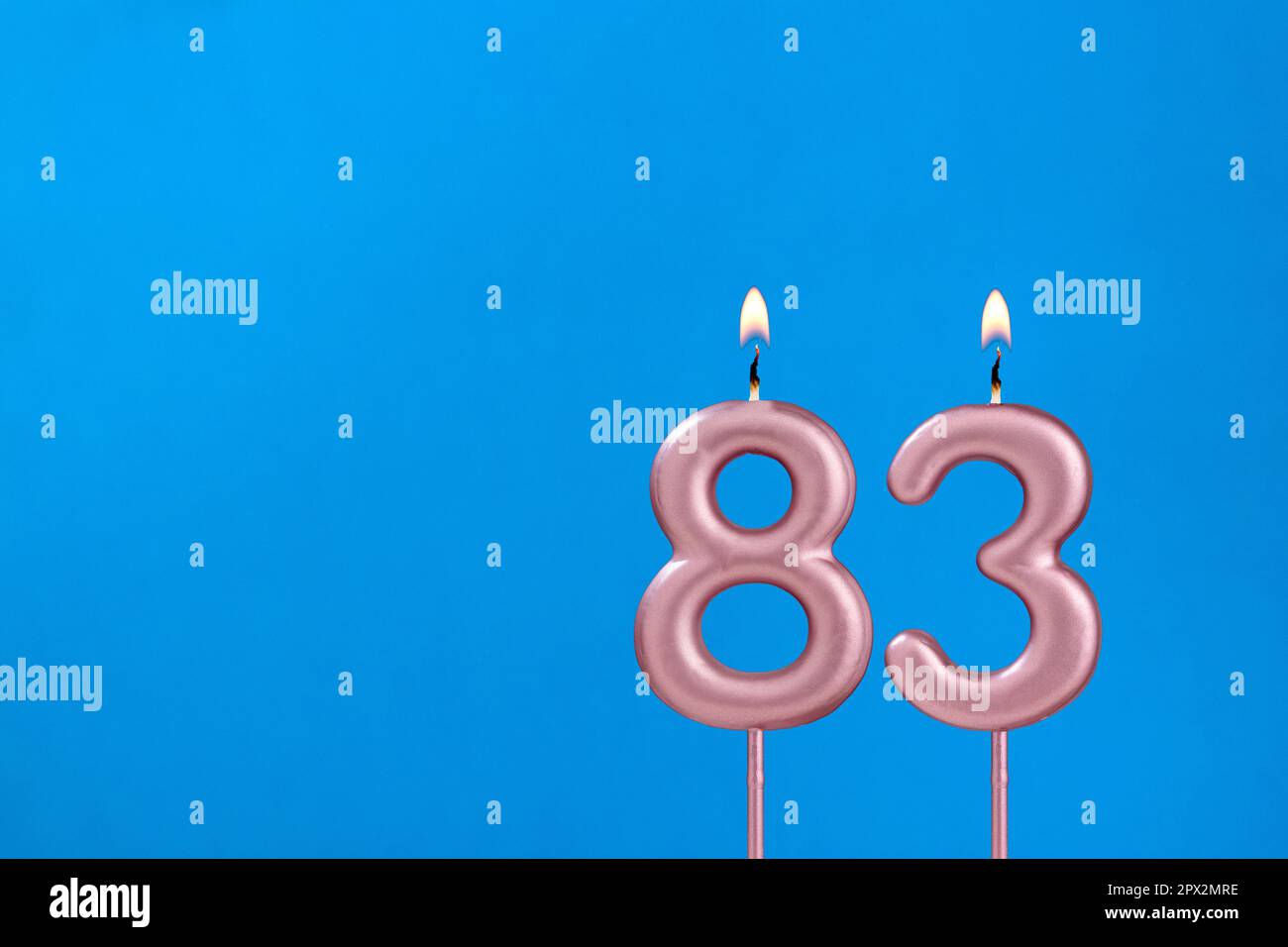 Number 83 - Burning anniversary candle on blue foamy background Stock ...