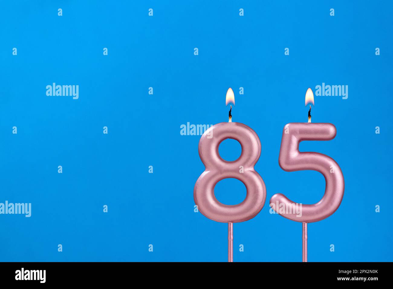 Number 85 - Burning anniversary candle on blue foamy background Stock ...