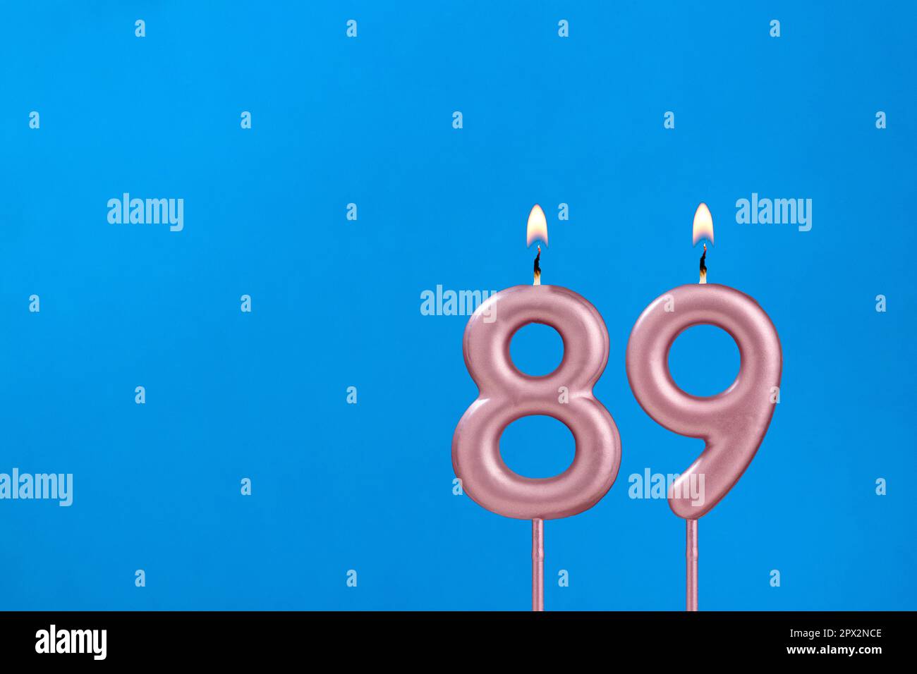 Number 89 - Burning anniversary candle on blue foamy background Stock ...