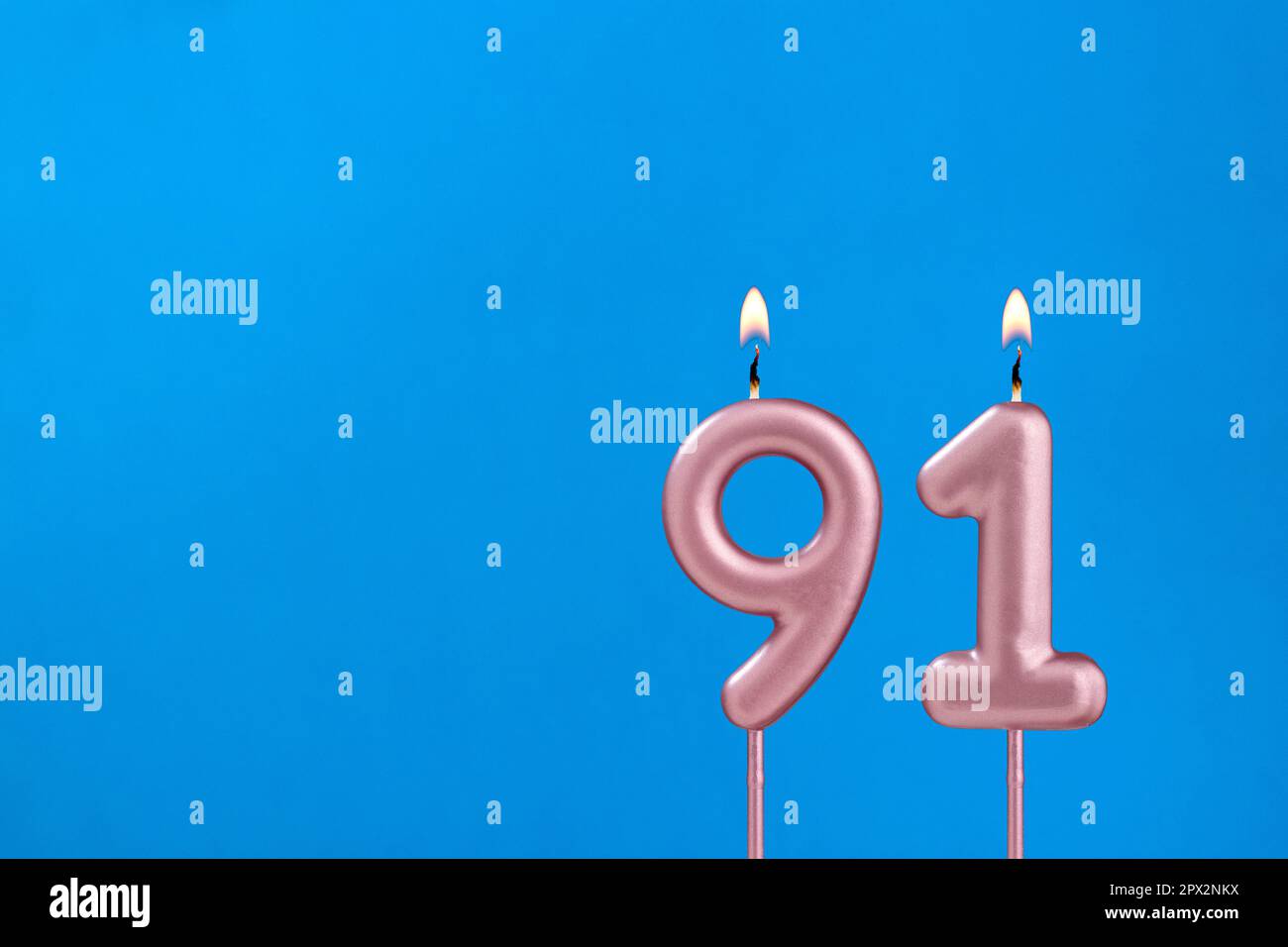 Number 91 - Burning anniversary candle on blue foamy background Stock ...