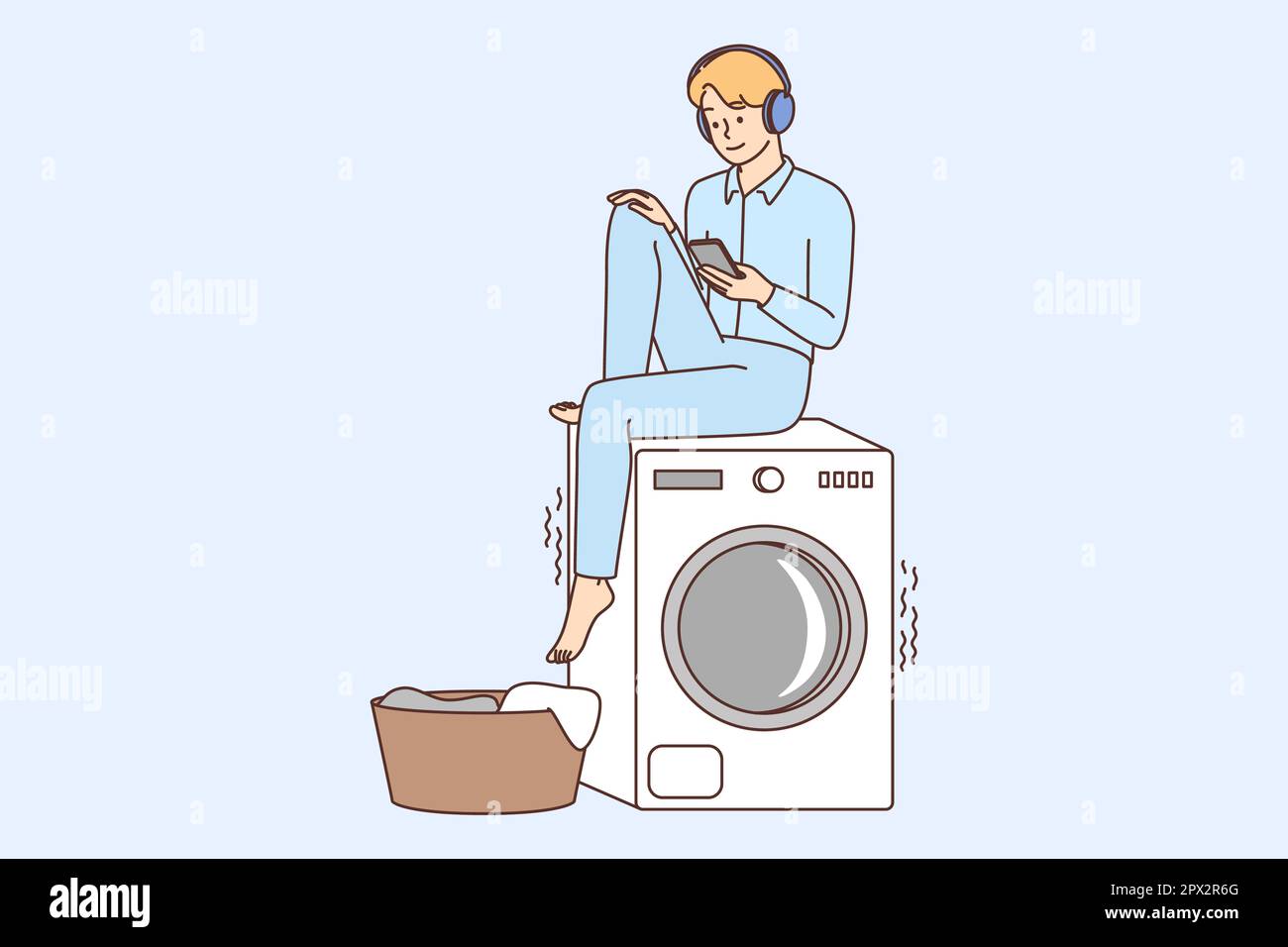 Young man in pyjama sit on washing machine listen to music. Smiling guy ...