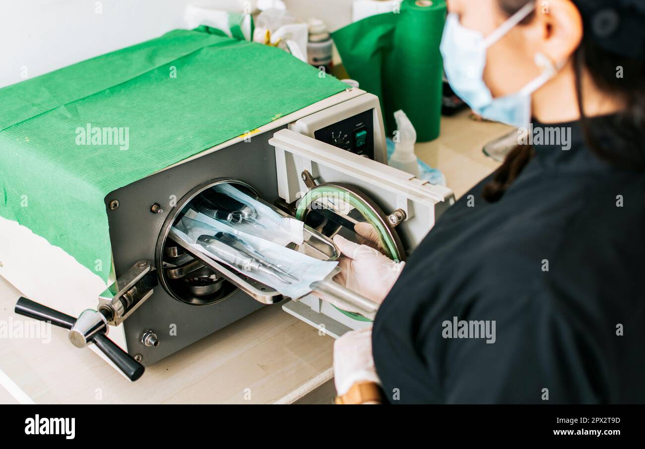 A dentist sterilizing his tools, Dentist with a dental sterilizer, A ...