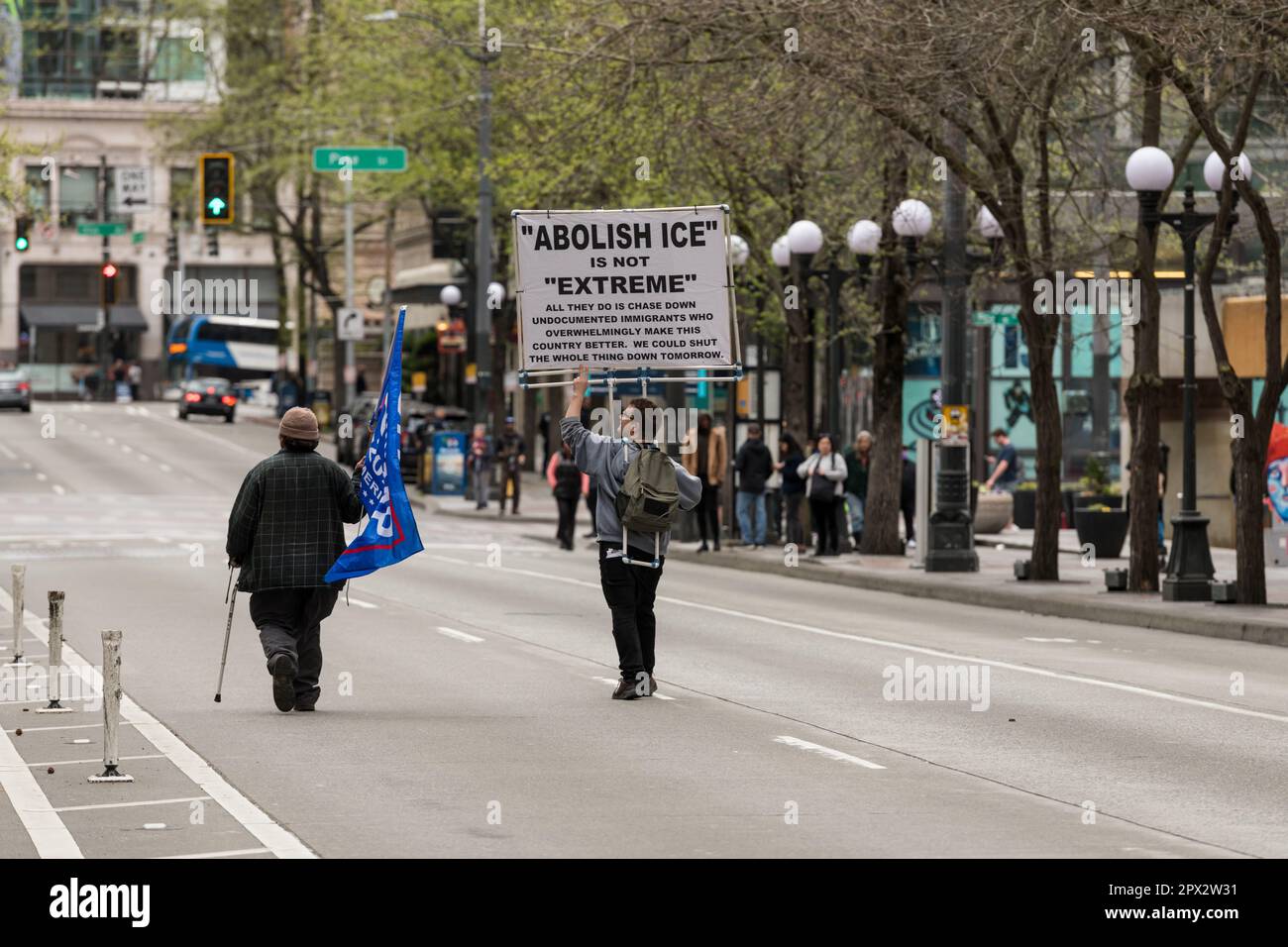 Seattle, USA. 1 May, 2023. A counter protestor with a Trump flag as ...