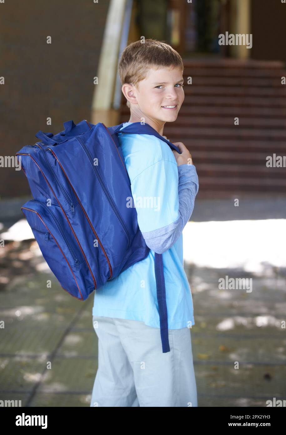 Back to school. A smiling young boy wearing a backpack on his way to ...