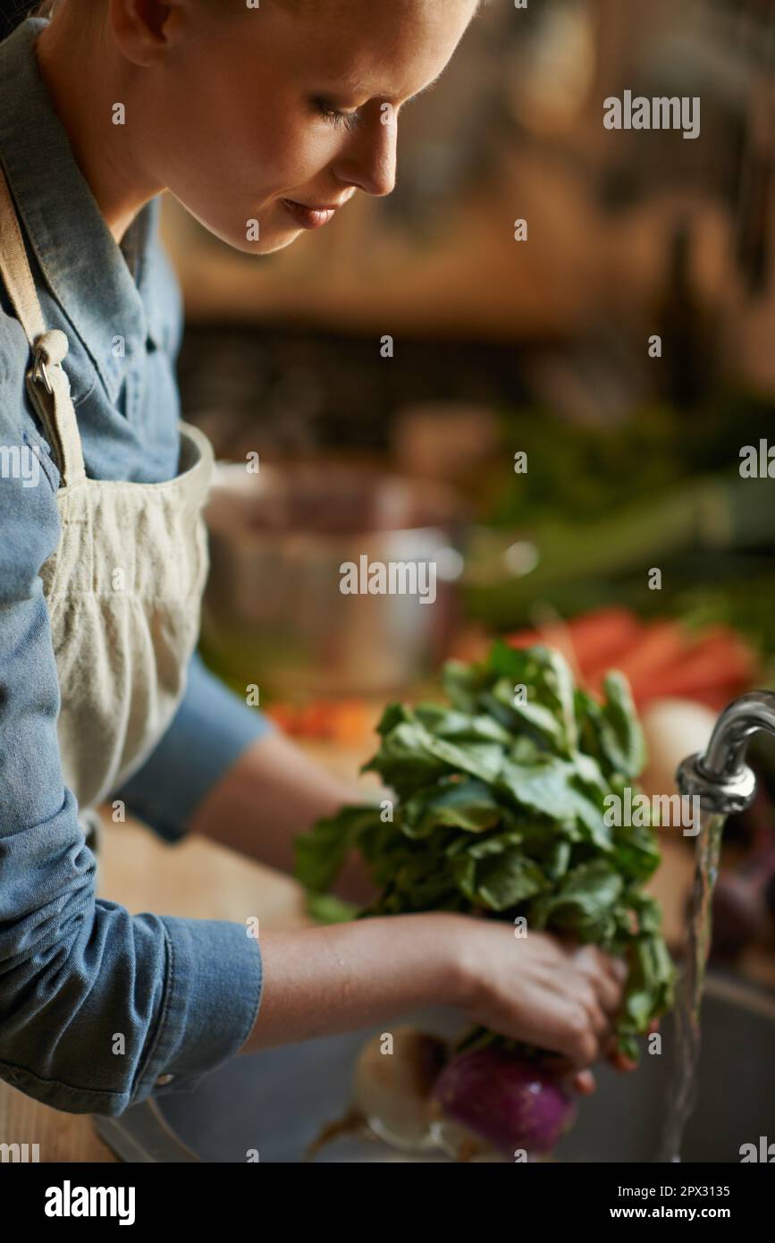 Fresh is the best. a young woman washing vegetables in a sink Stock ...