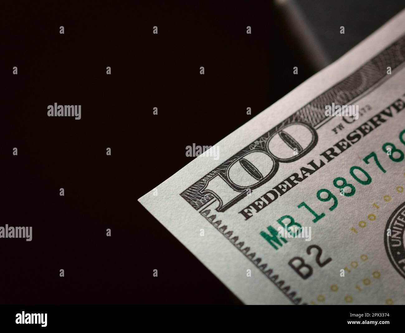 One hundred dollar bill. Focus on a corner, showing the number, with ...