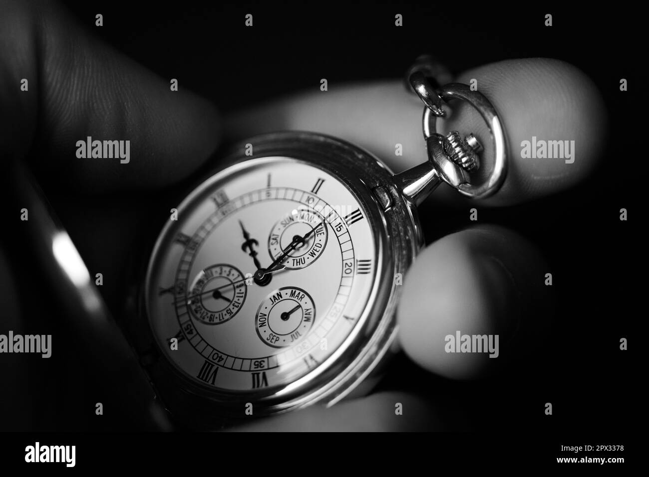 Hand holding a luxury pocket watch. Extreme close up, black and white ...