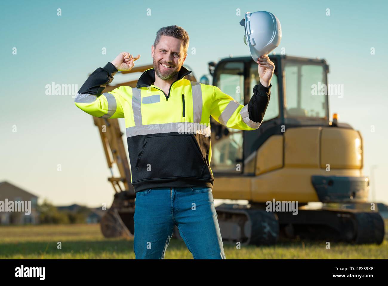 Portrait of builder in a construction site. Builder with excavator ...
