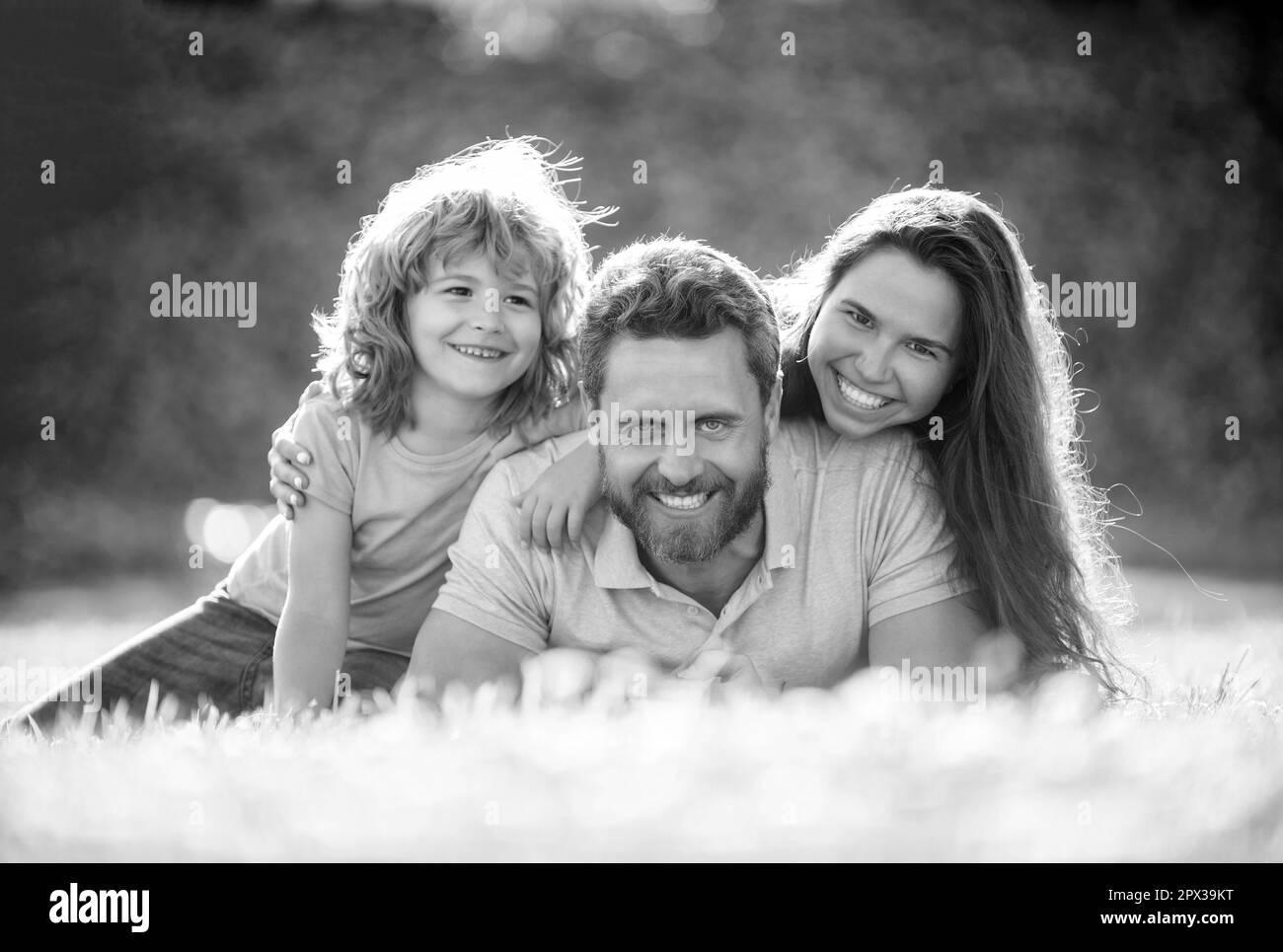 happy family of mom dad and son kid relax in summer park green grass ...