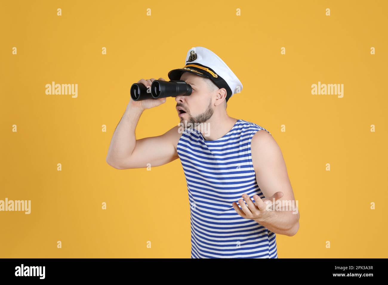 Sailor looking through binoculars on yellow background Stock Photo - Alamy