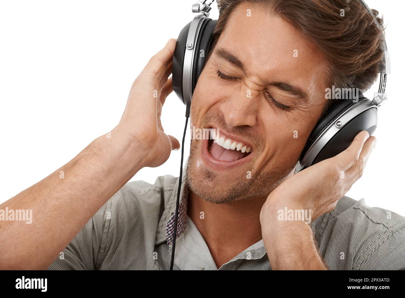Singing along with his favourite song. A handsome young man listening ...