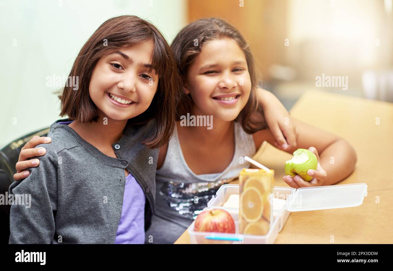 Break time besties. Portrait of young school children eating lunch at ...