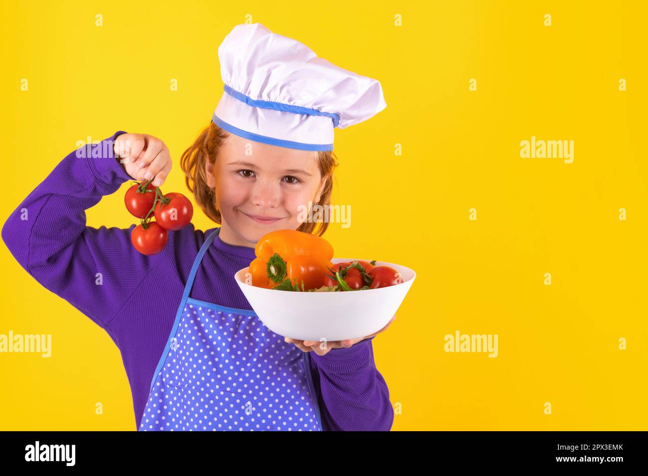 Kid cook hold tomato. Excited chef cook. Child wearing cooker uniform ...