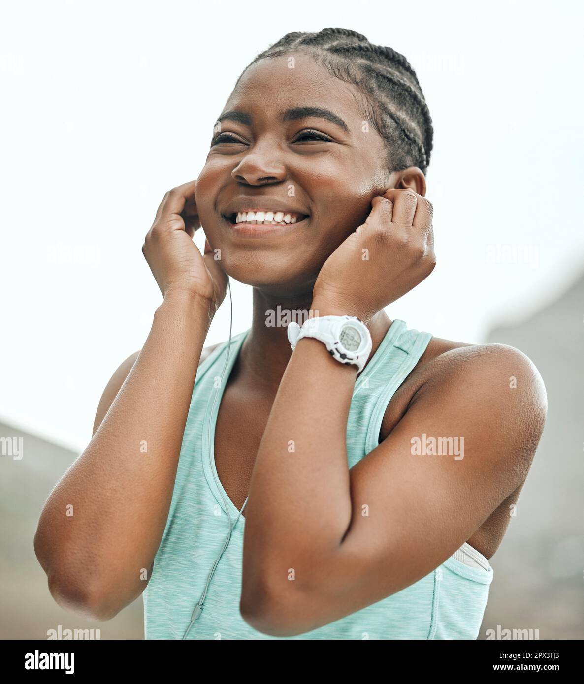 Music makes me feel great. a young woman listening to music while on a ...