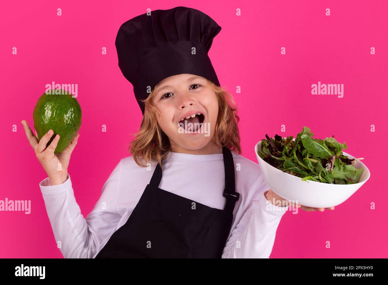 Funny child cook with avocado and vegetable. Kid chef cook, studio ...