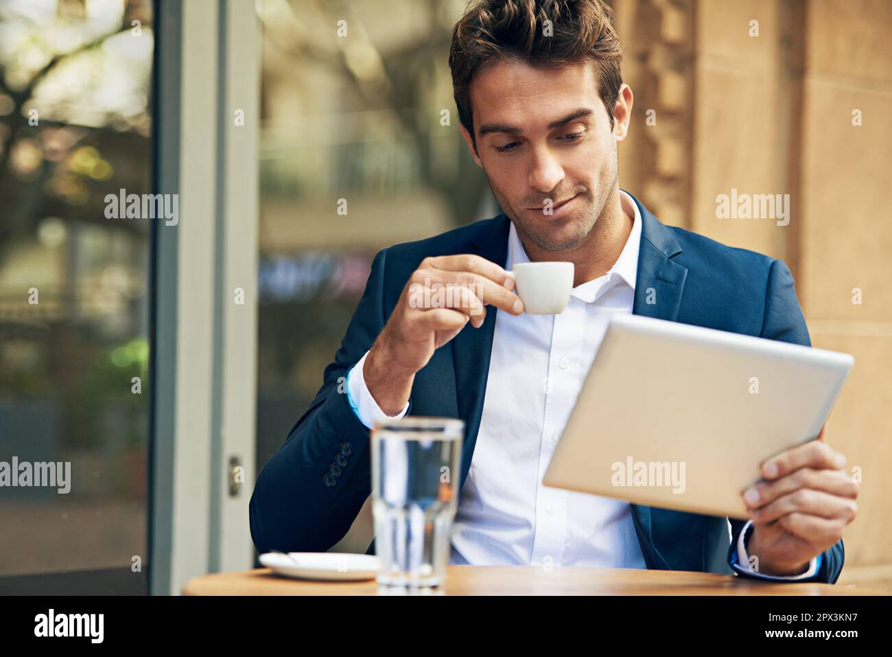 Catching up on the latest business news. A young businessman using his ...