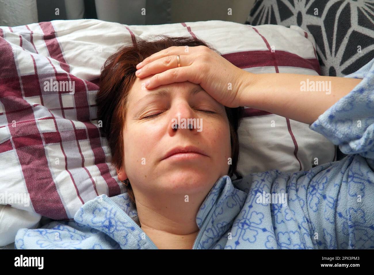 Sick woman in bed. Headache, runny nose and cold. Paleness of the face ...