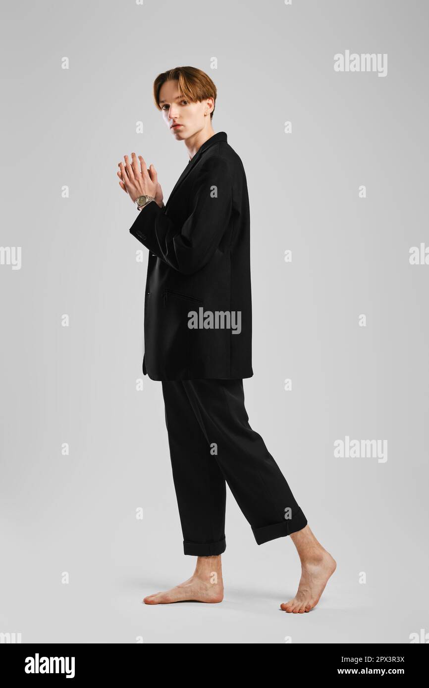 Young barefoot man in black suit posing in studio Stock Photo - Alamy