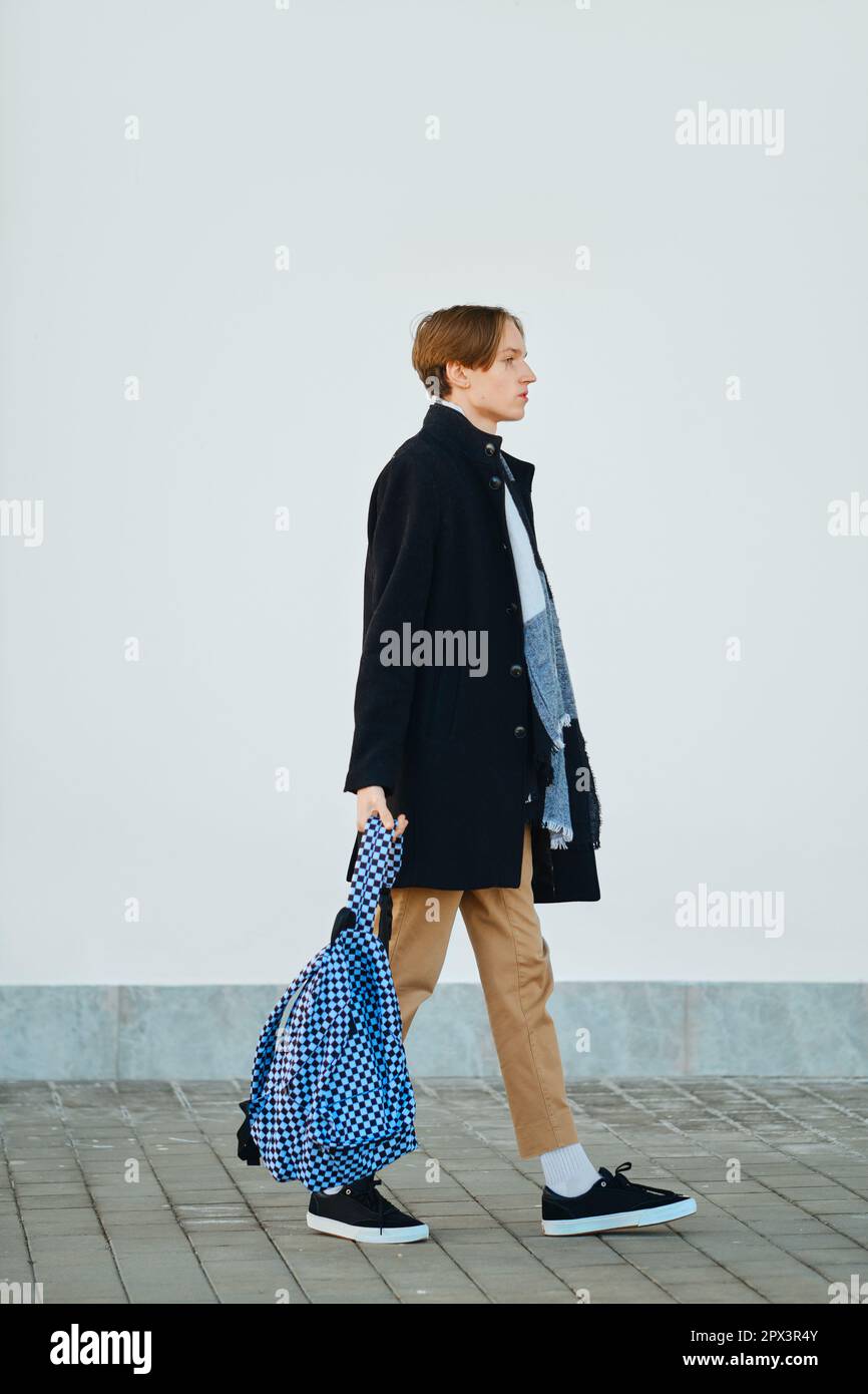 Full length portrait of young student walks with backpack in old wool ...
