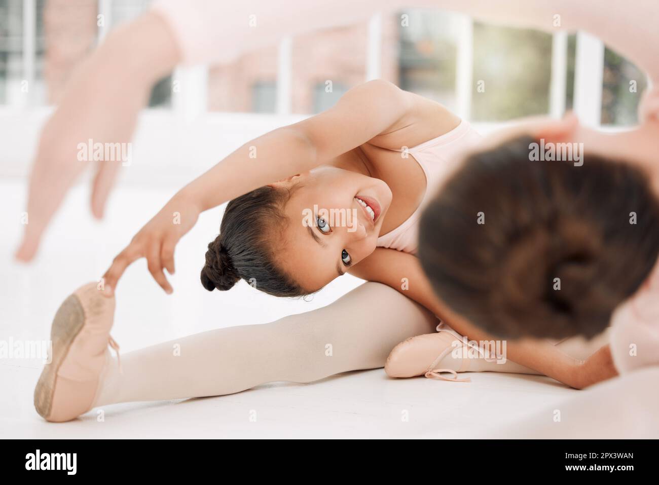 I can reach my toes. a little girl stretching in a dance studio Stock Photo - Alamy
