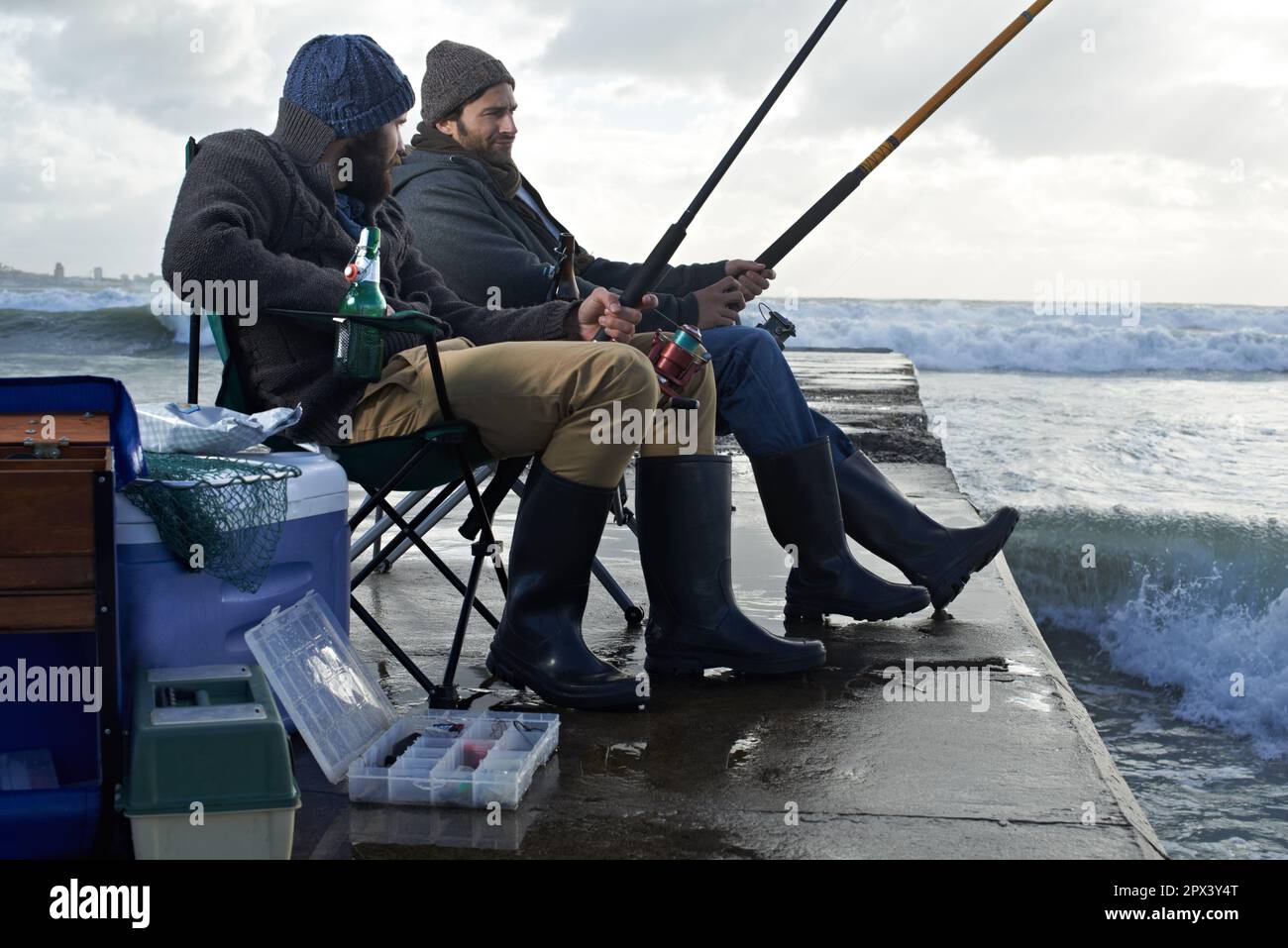 Hanging out, just catching some fish. two young men fishing at the ...