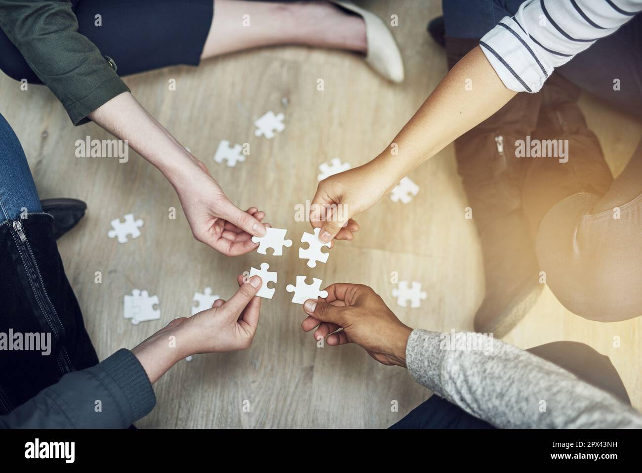 Building on to each other. a group of people building a puzzle together ...