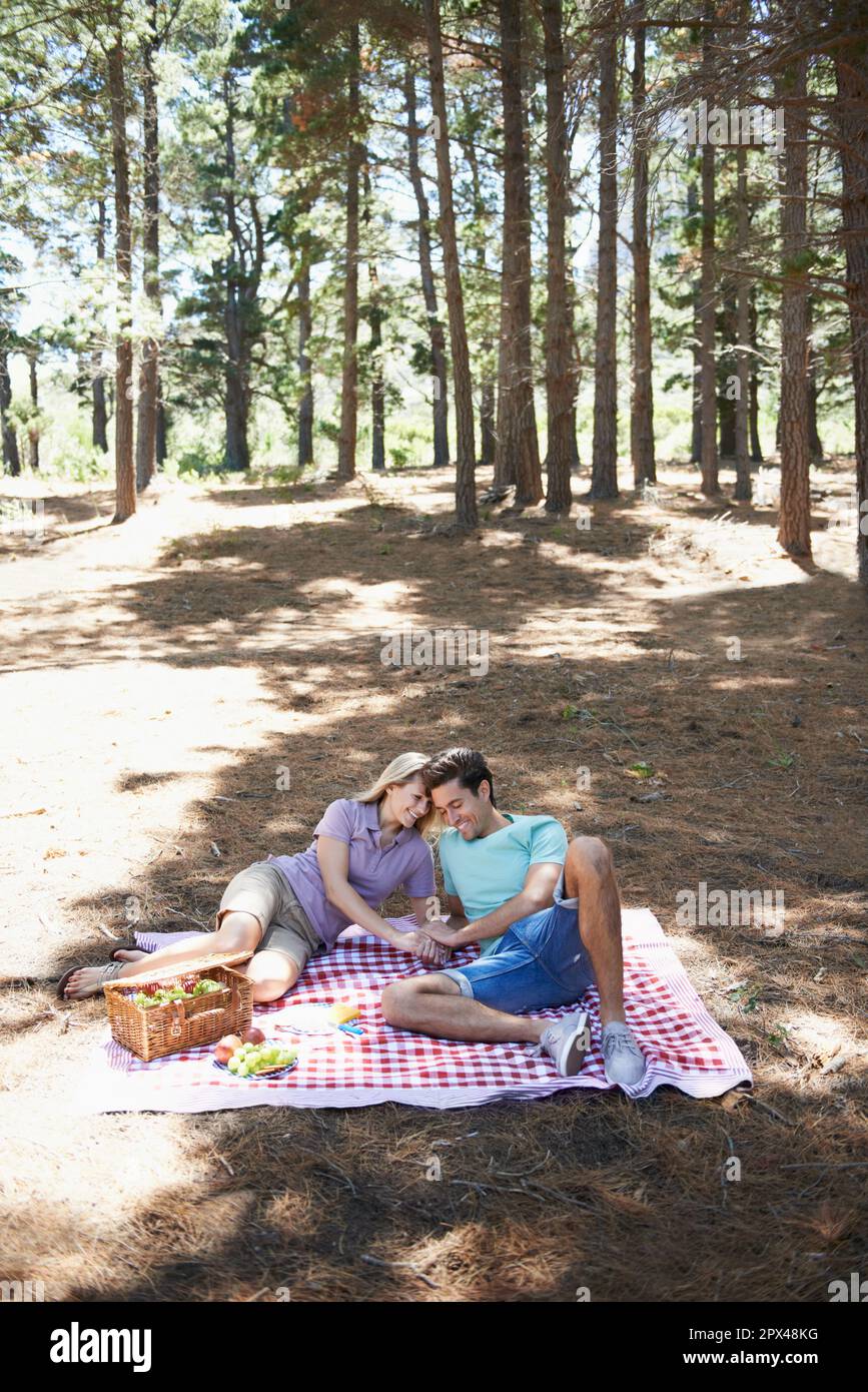 The perfect forest picnic. View of a happy young couple enjoying a ...