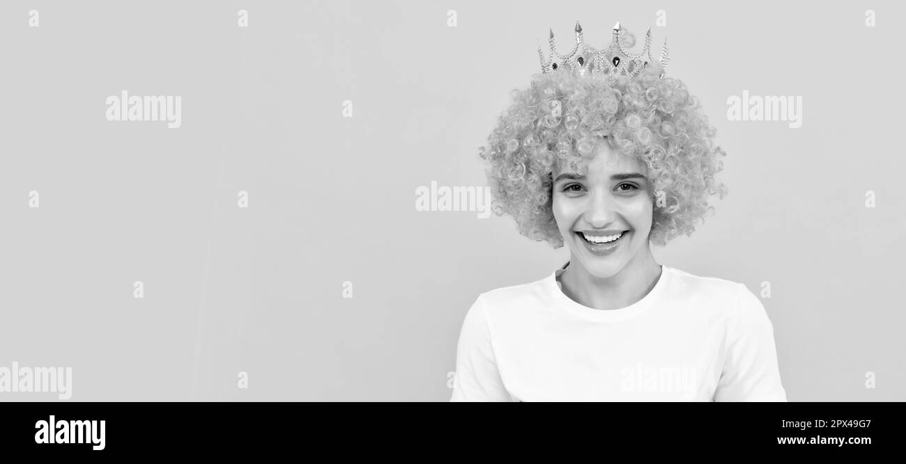 happy freaky selfish woman in curly clown wig and queen crown for party ...
