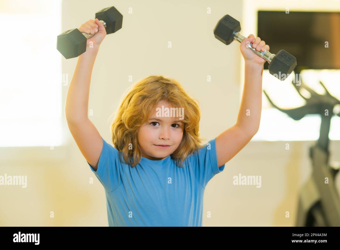 Child workout kid in gym. Sport activities at leisure with children. Blonde boy holding ...