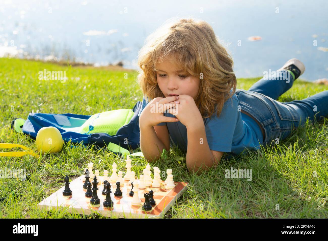 Kid thinking of chess. Little child play chess. Kid playing board game ...