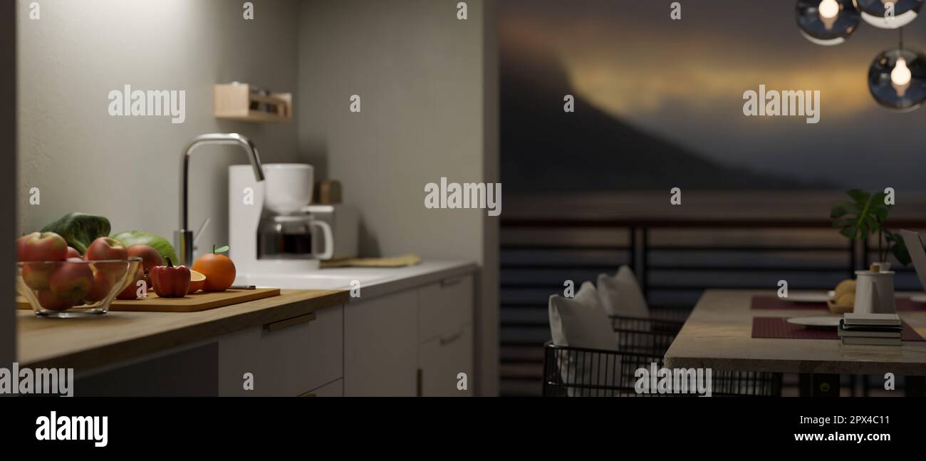 Side view of a modern contemporary kitchen with dining table at night ...