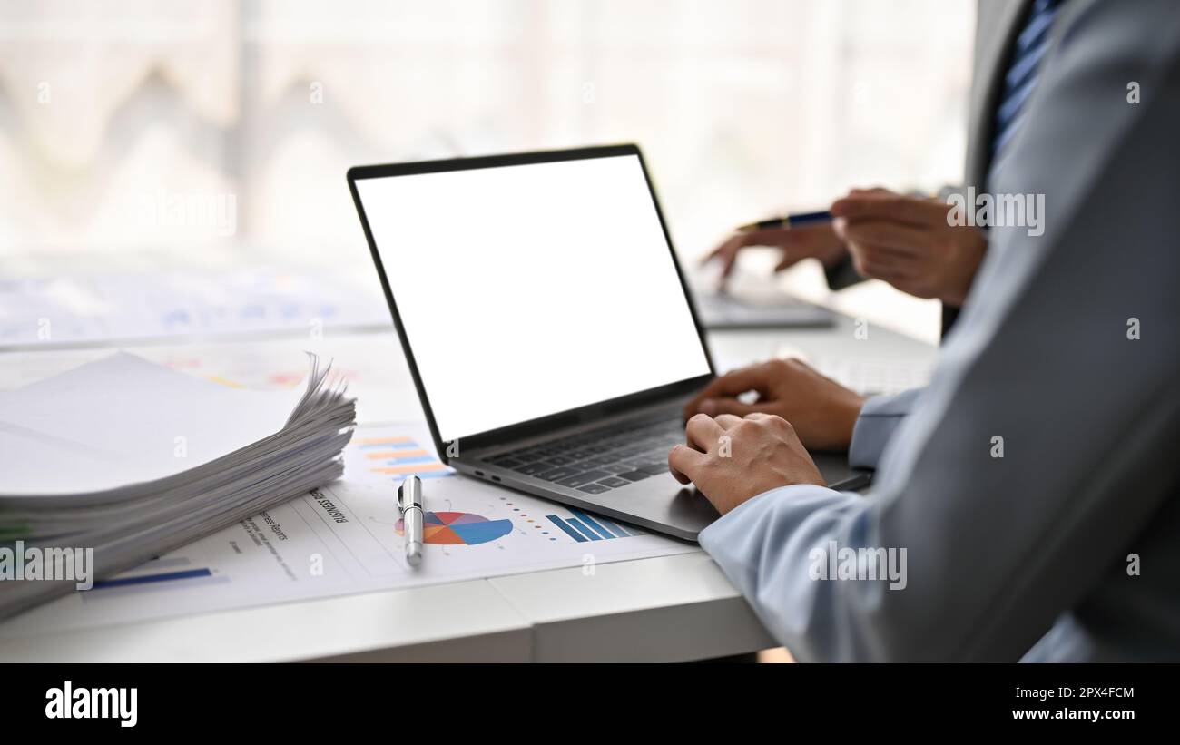 Close-up image of a businessman using his laptop computer while having ...