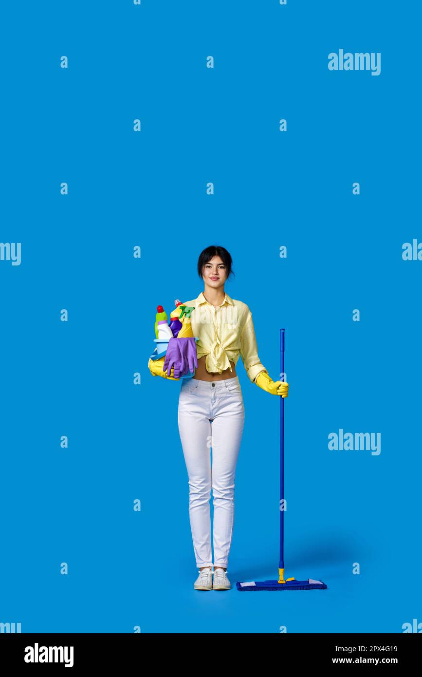pretty housewife girl in yellow rubber gloves with mop holding bucket ...
