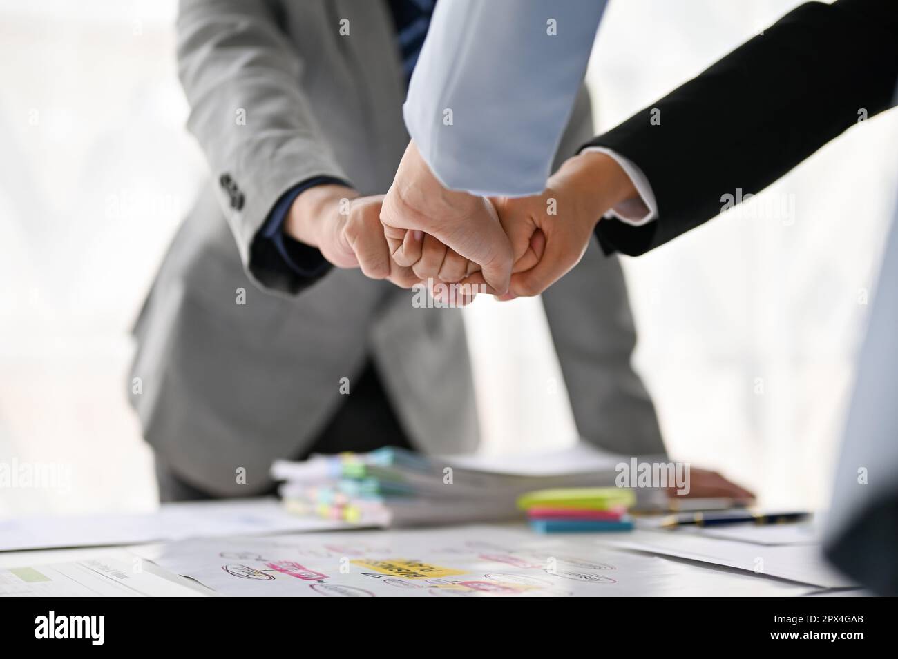 Close-up image of diverse businesspeople bumping their fists together ...