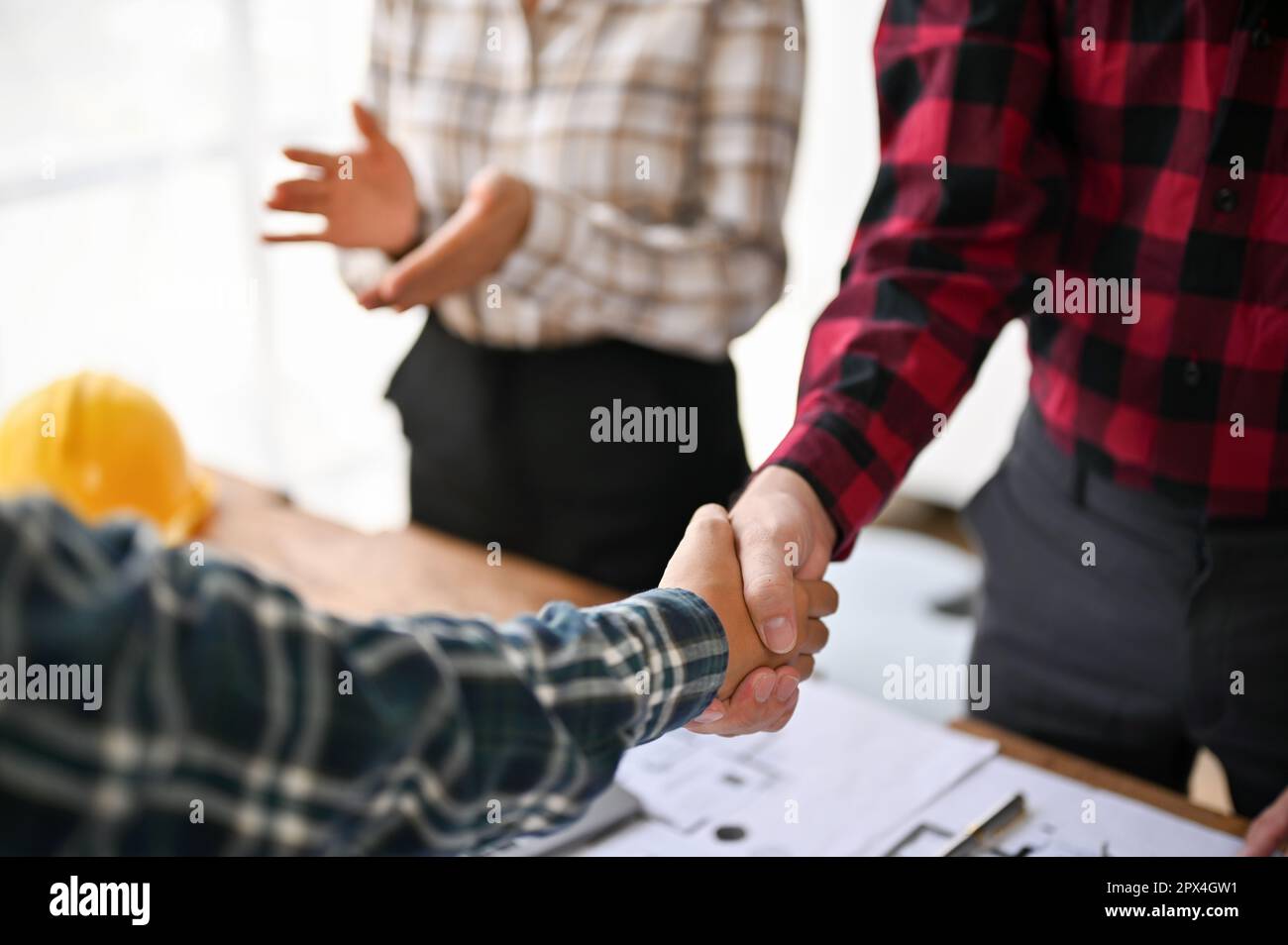Close-up image of an engineer shaking hands with his coworker during ...