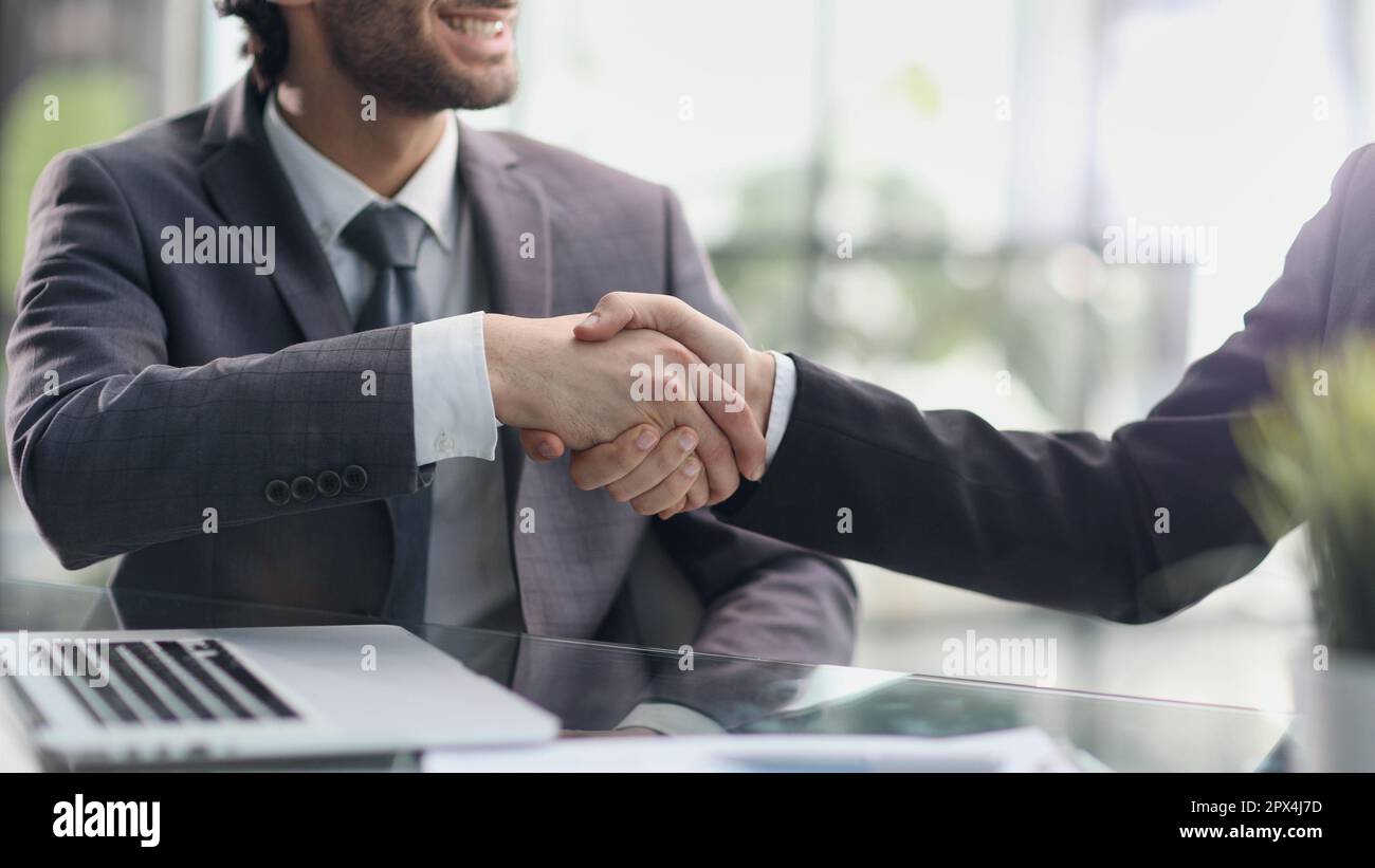 man Manager welcomes the client with a handshake Stock Photo - Alamy
