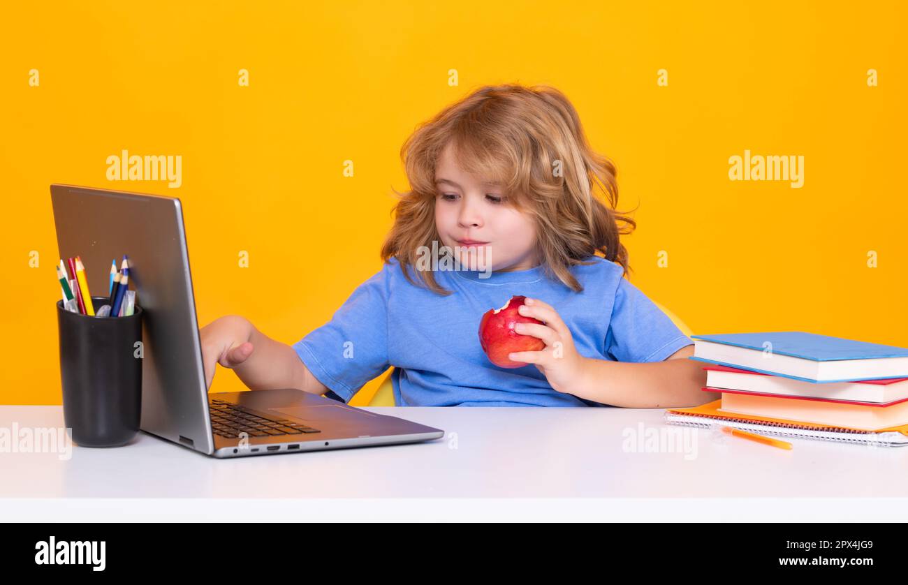 School child using laptop computer. Nerd school kid isolated on studio ...