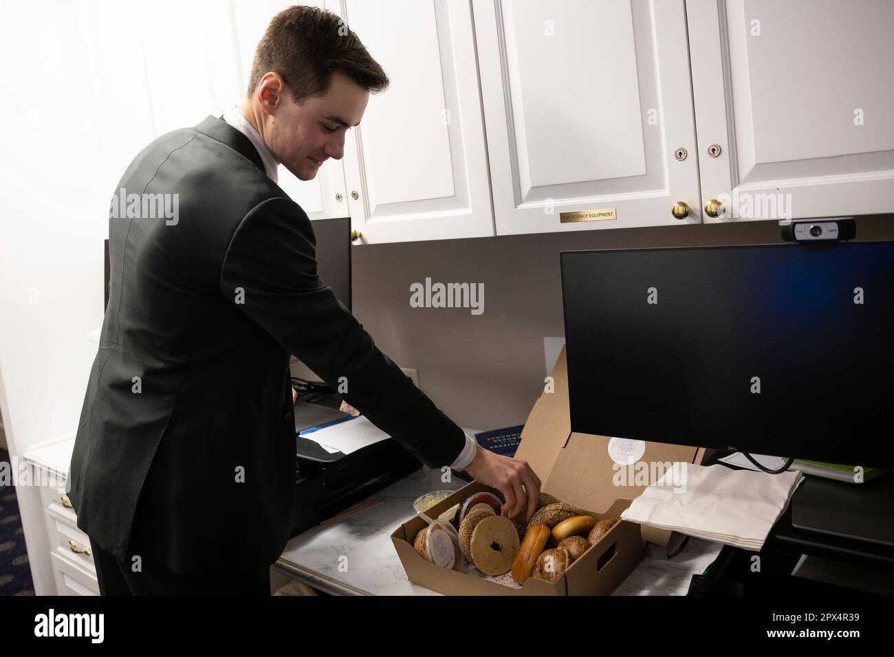 White House Press Assistant Davis Conger reaches for a bagel in the ...
