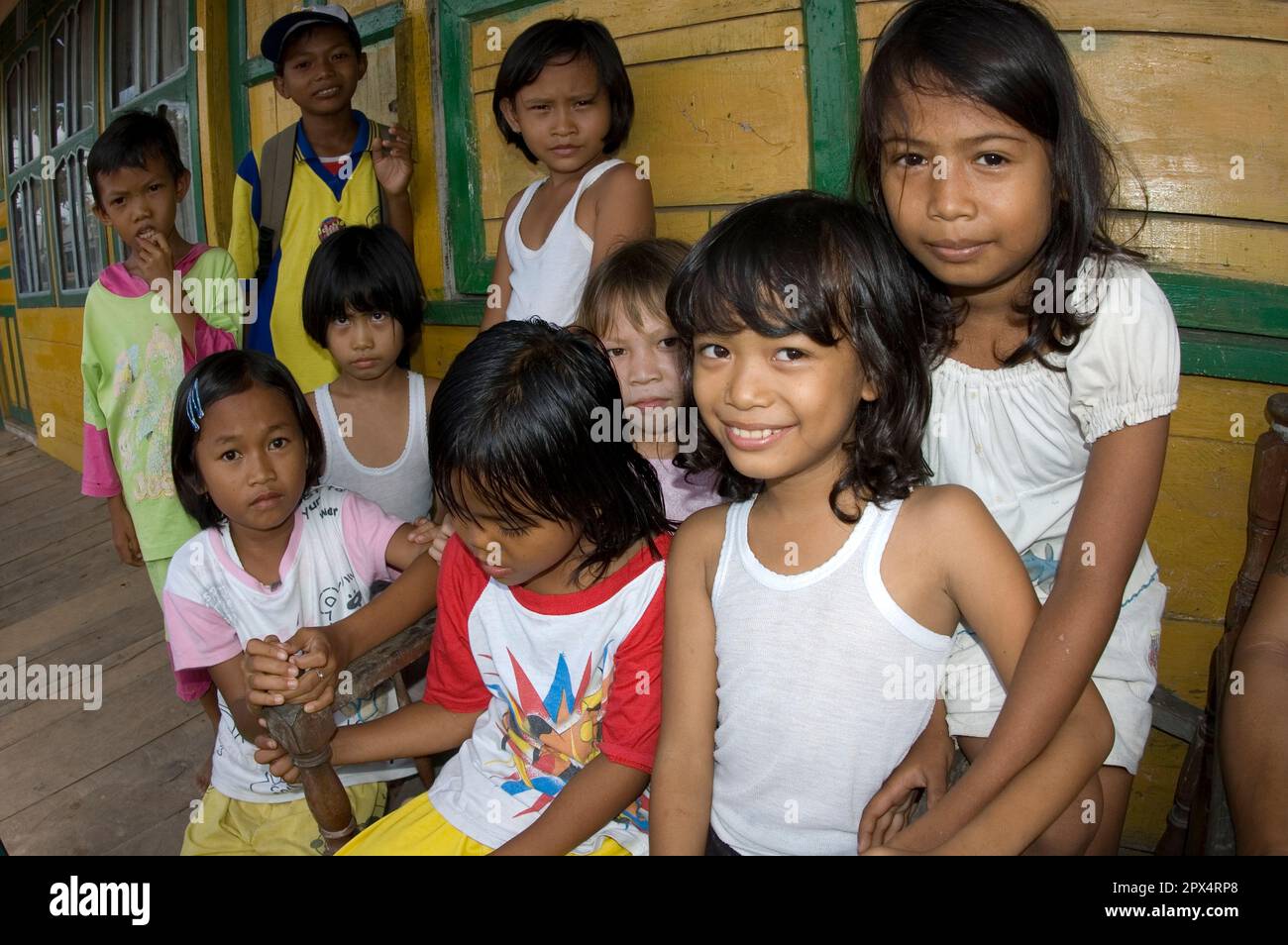 Children on bench on shack patio, Bayung Lencir, near Jambi, Sumatra ...