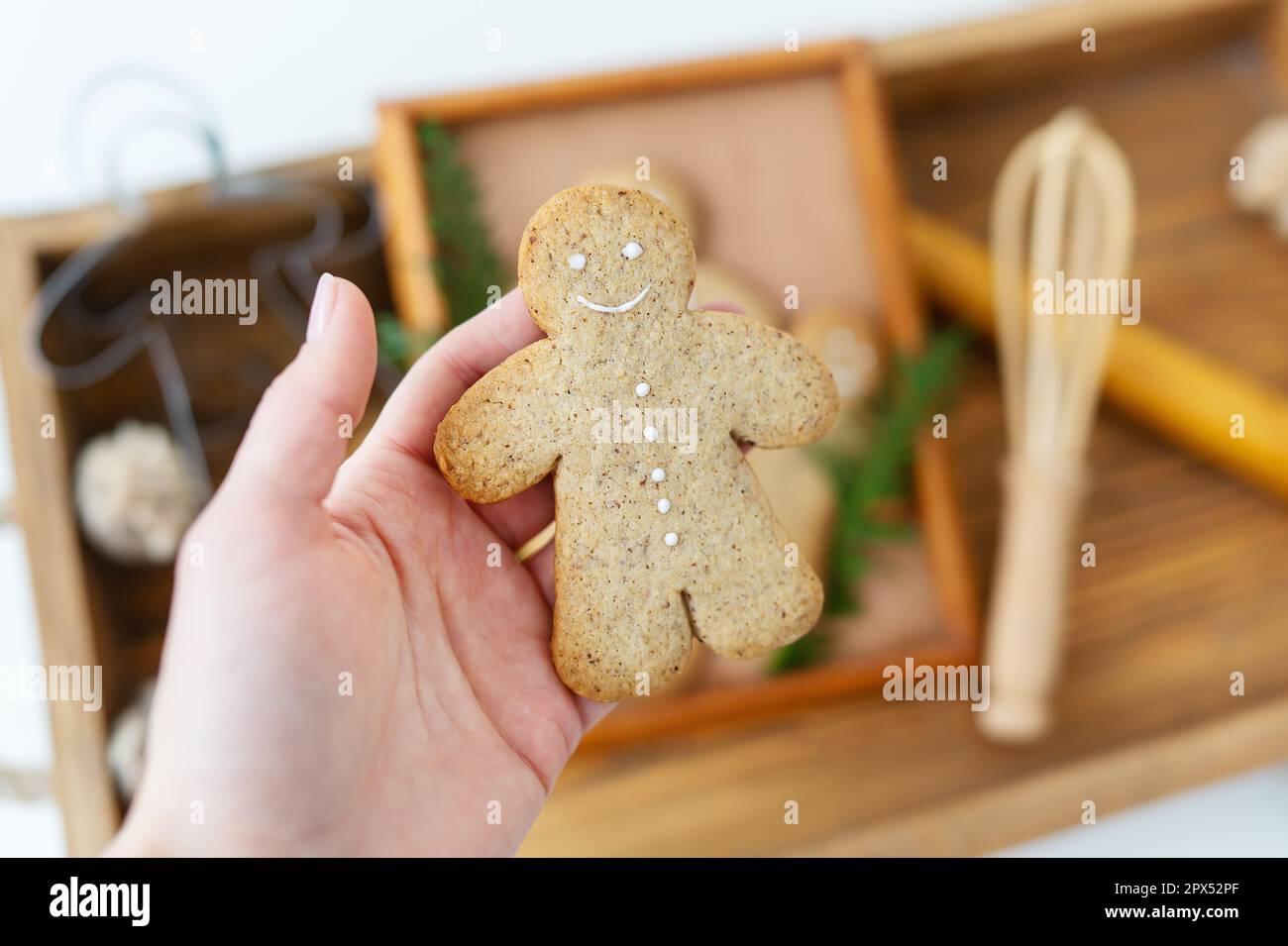 A woman's hand holds a gingerbread man. Cooking gingerbread at home ...